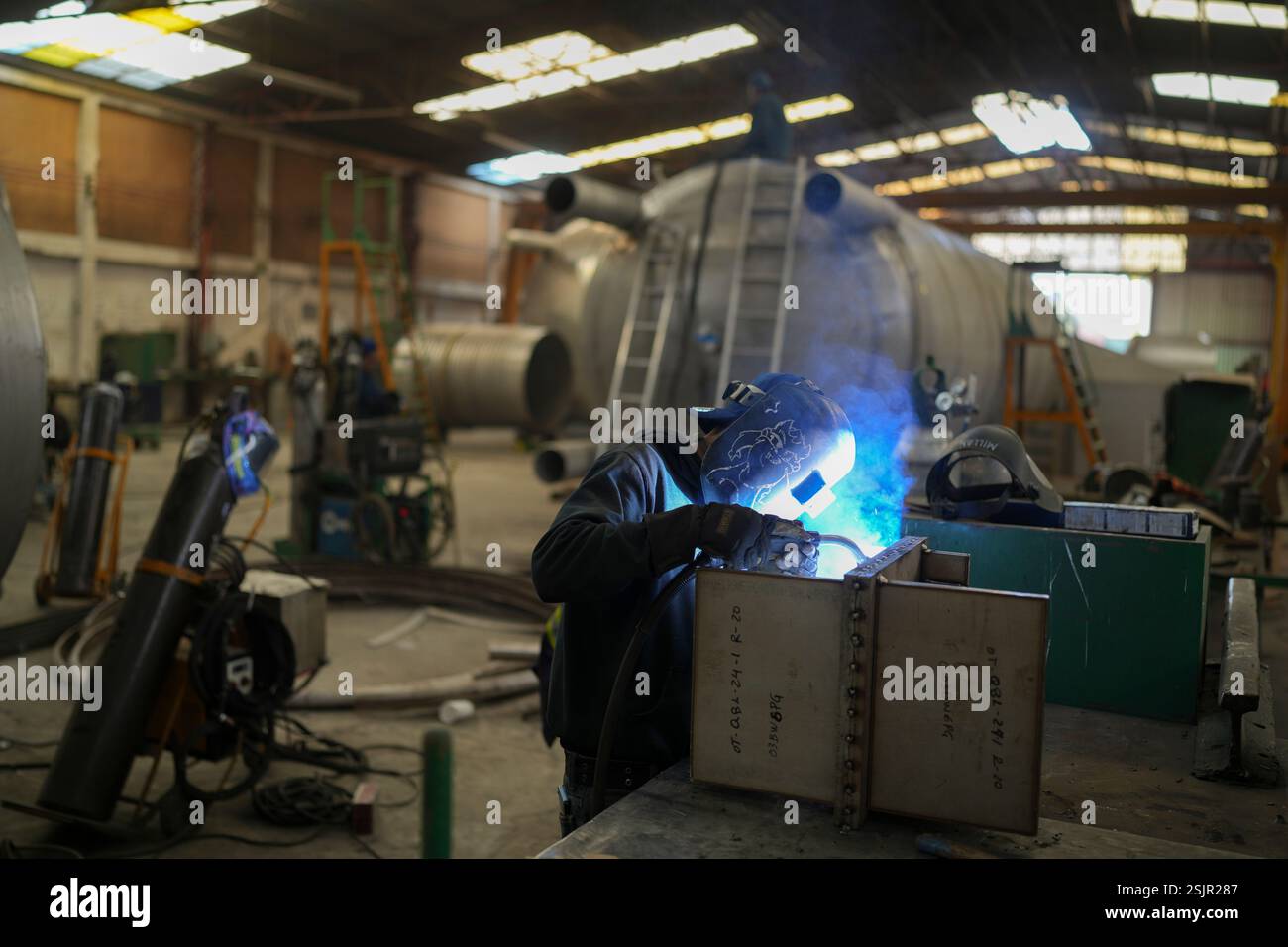 An employee welds metal at a steel tank factory in Mexico City, Tuesday ...