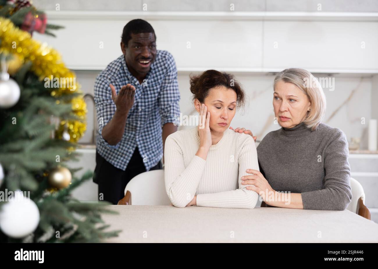 Domestic quarrel during Christmas celebration. Mom calms her daughter ...