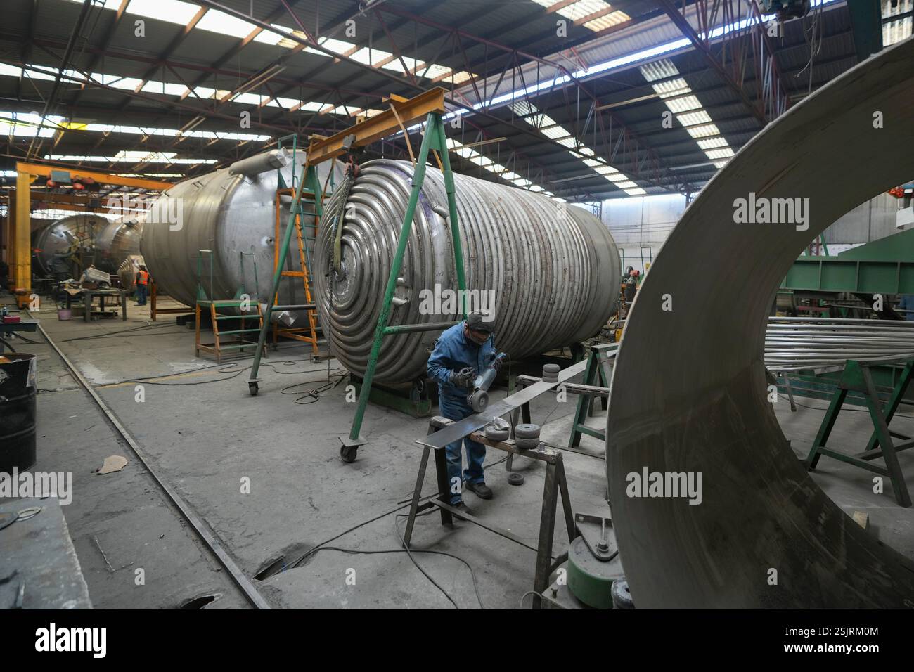 An employee works at a steel tank factory in Mexico City, Tuesday, Feb ...