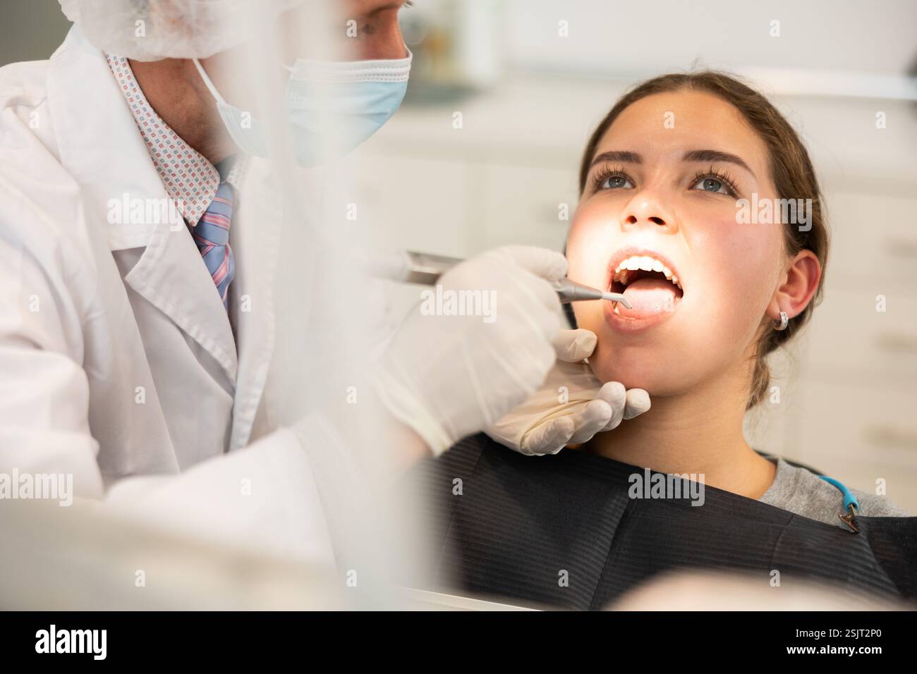 Male dentist treats patients teeth hi-res stock photography and images ...