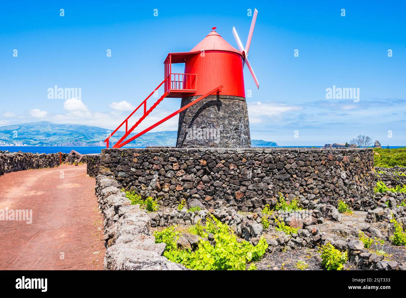 Historic windmill building among vineyard culture and volcanic rocks ...