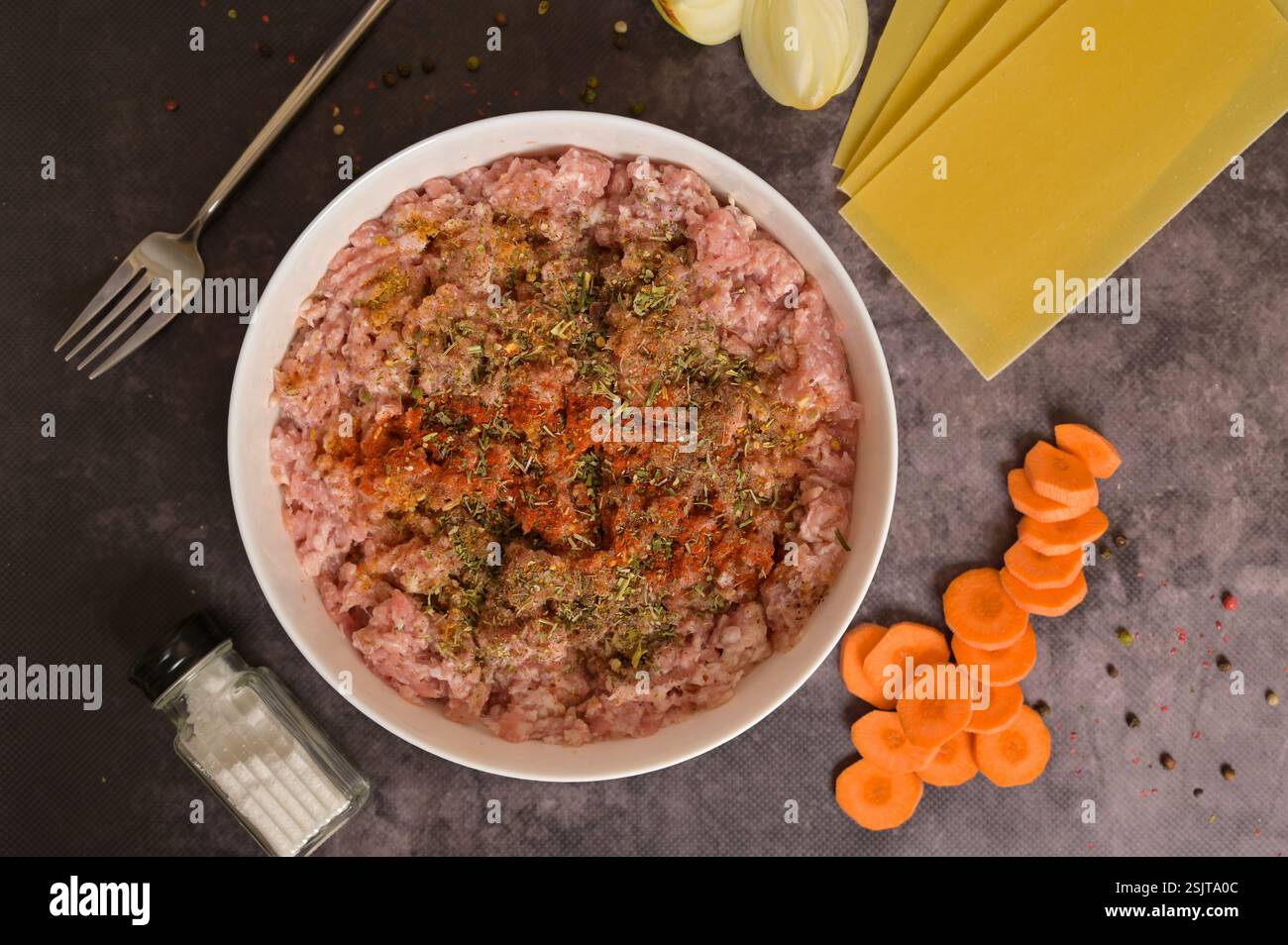 Top view raw ground minced meat in white bowl with spices. Lasagne ...