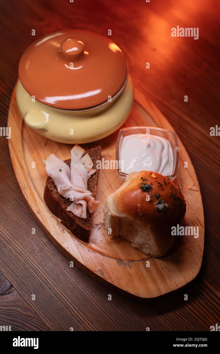 Restaurant dish borscht, delicious bread with bacon, sour cream, bun. A ...