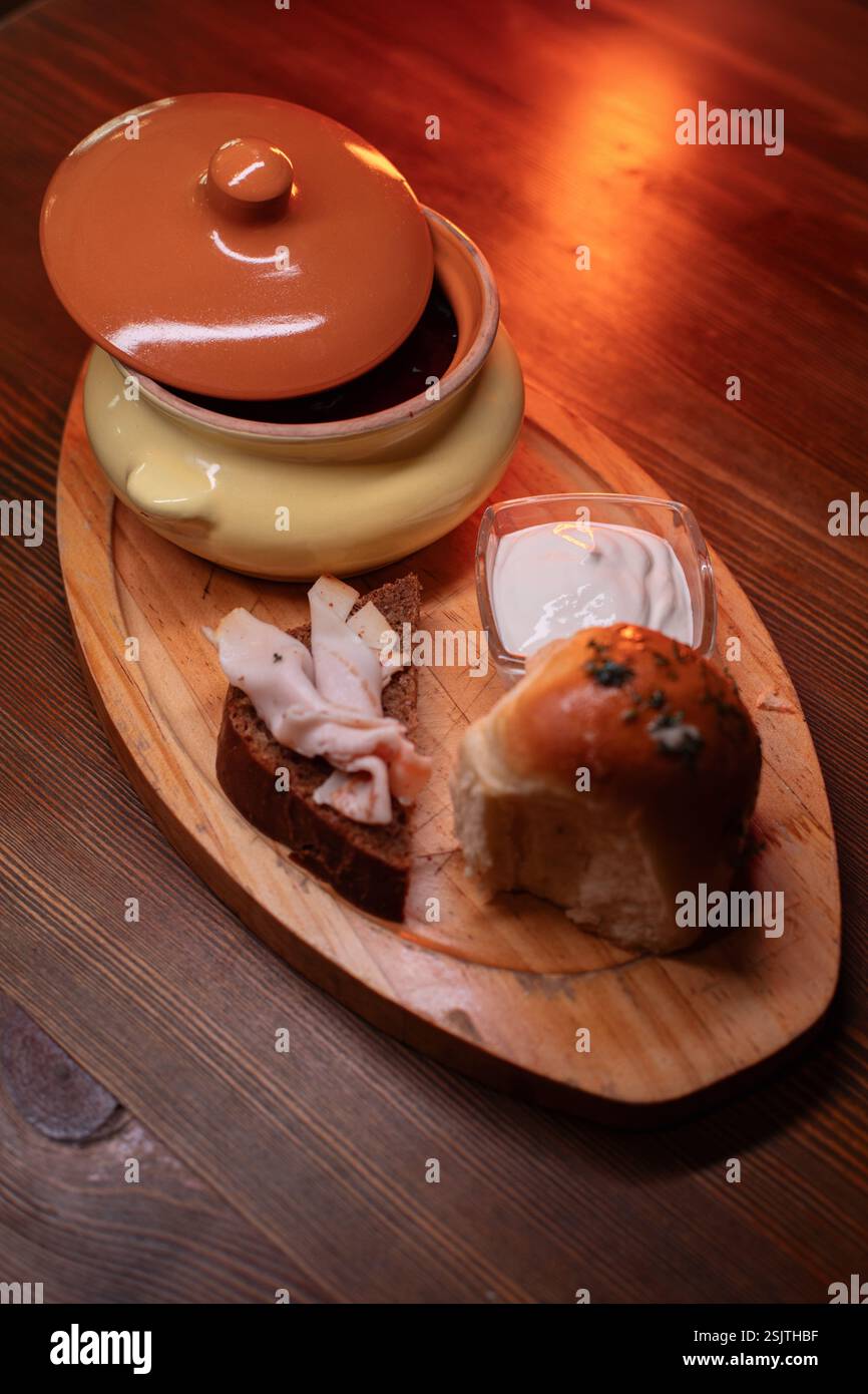 Restaurant dish borscht, delicious bread with bacon, sour cream, bun. A ...