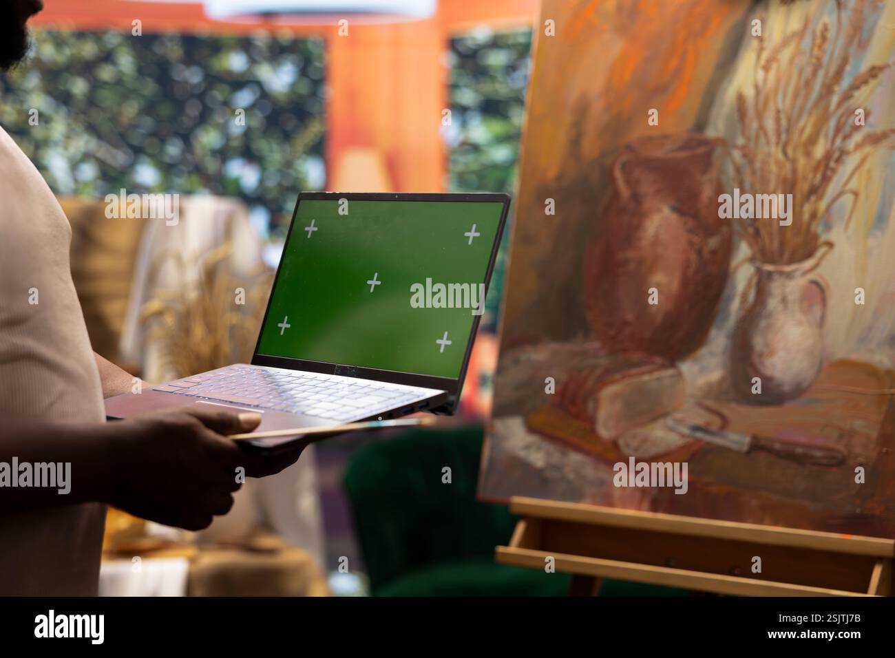 Young artist looking at isolated chroma key display in his painting ...