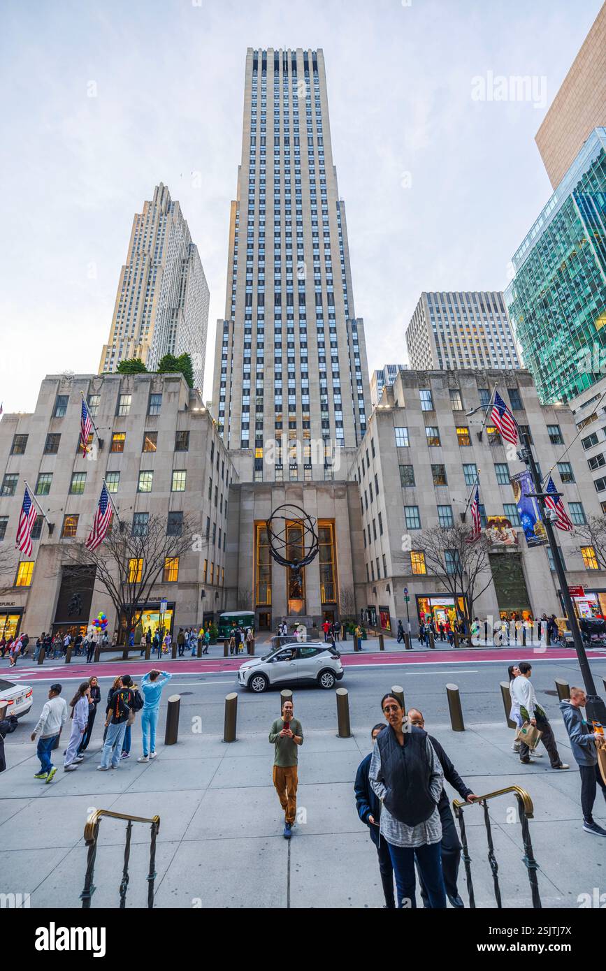 Rockefeller Center skyscraper with Atlas statue and pedestrians on busy ...