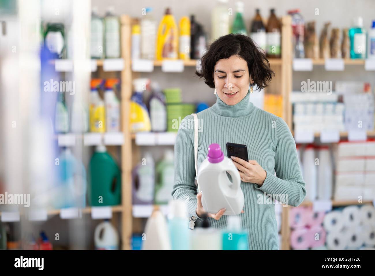Adult woman scanning qr code for detergent Stock Photo - Alamy