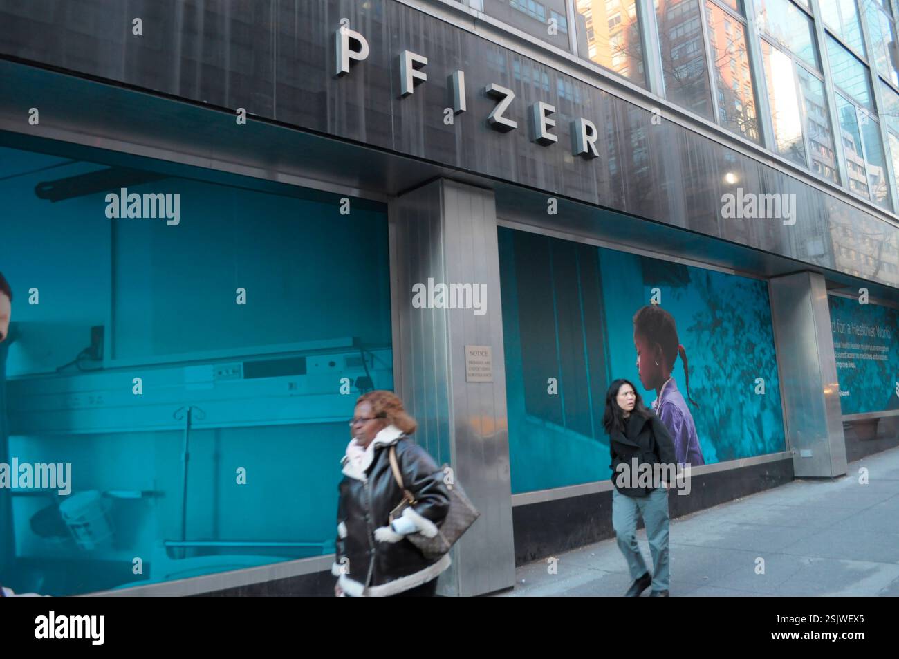 People walk past the Pfizer world headquarters building in Manhattan ...