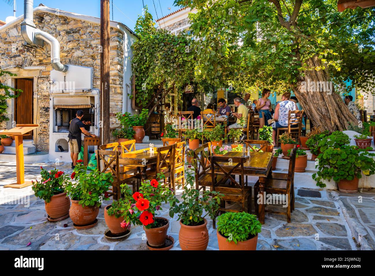 FILOTI VILLAGE, NAXOS ISLAND: SEP 26, 2024: People dining in typical ...