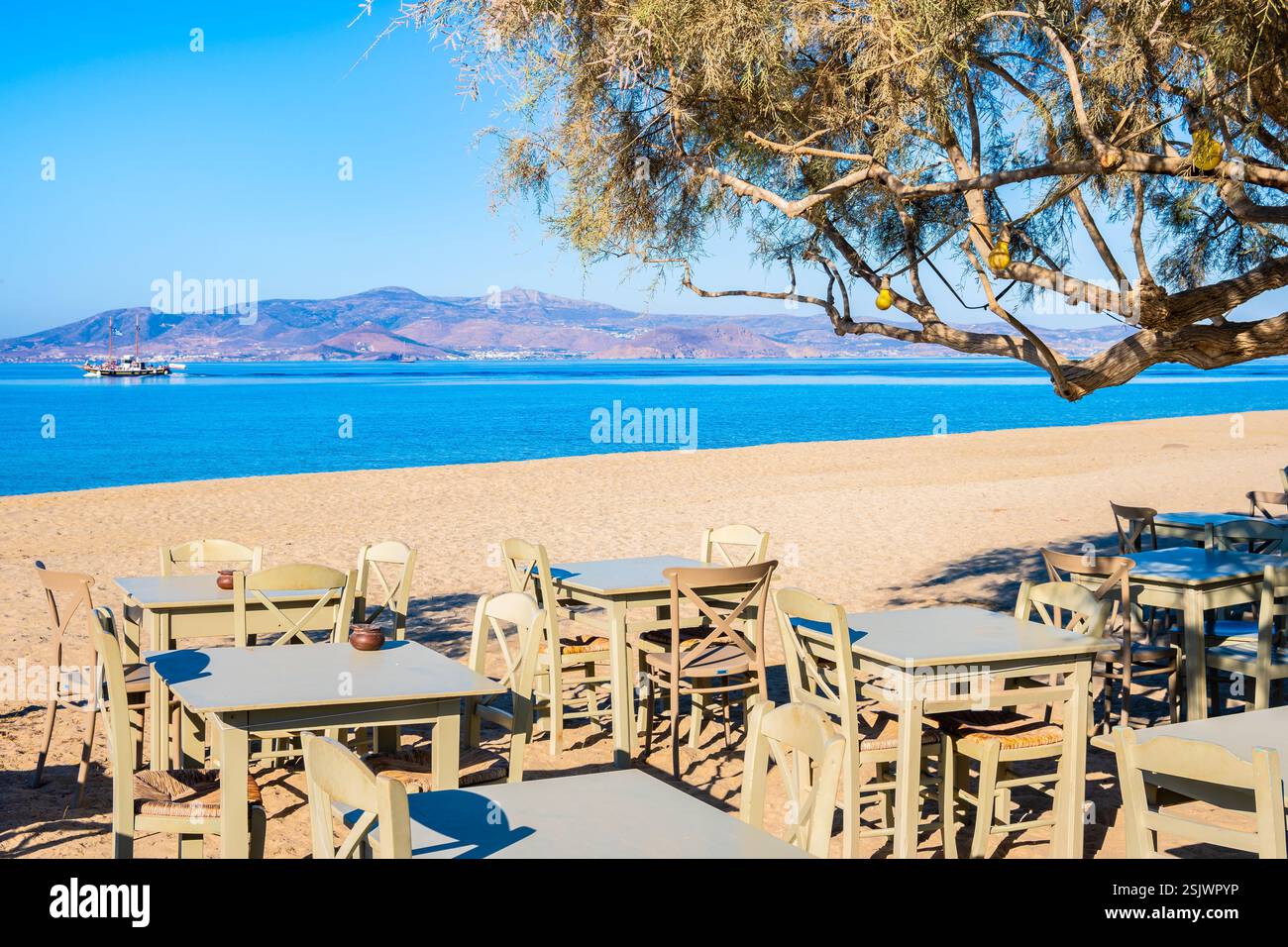 Tables with chairs in Greek taverna restaurant on Maragas beach and sea ...