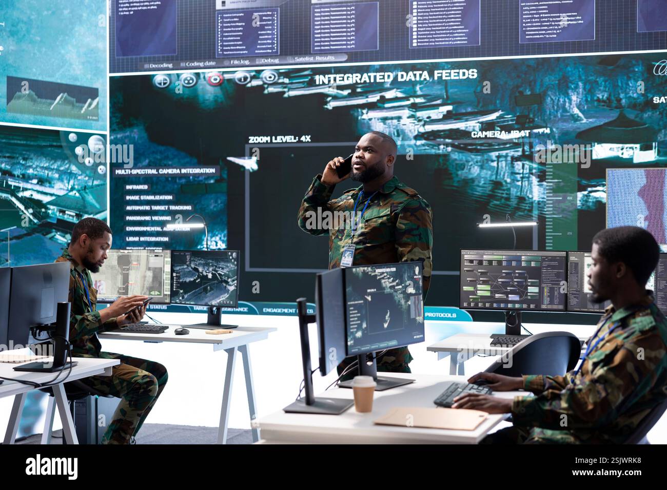 Military team in monitoring room uses advanced technology for intelligence gathering, including ...