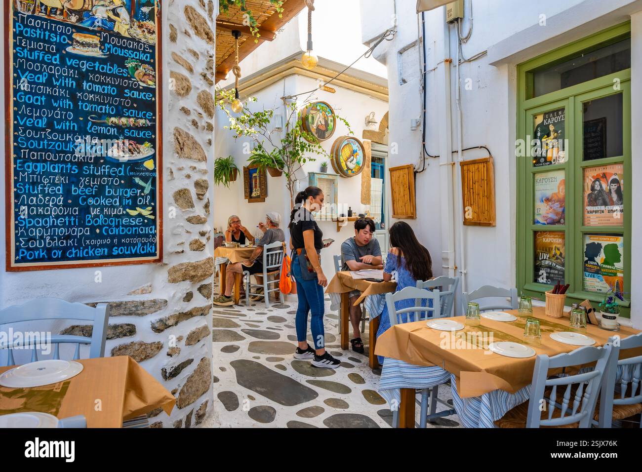 CHORA OLD TOWN, NAXOS ISLAND: SEP 29, 2024: People dining in typical ...