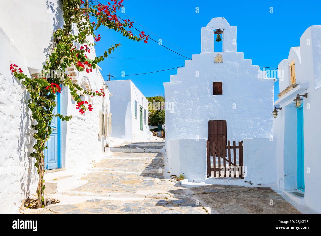 White church in narrow street of Chora village, Amorgos island ...