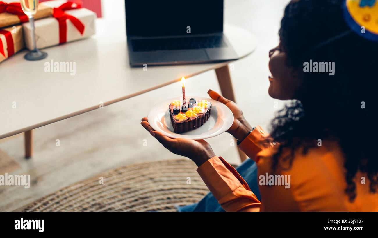 African American Woman At Laptop Holding Birthday Cake Indoor, Back ...