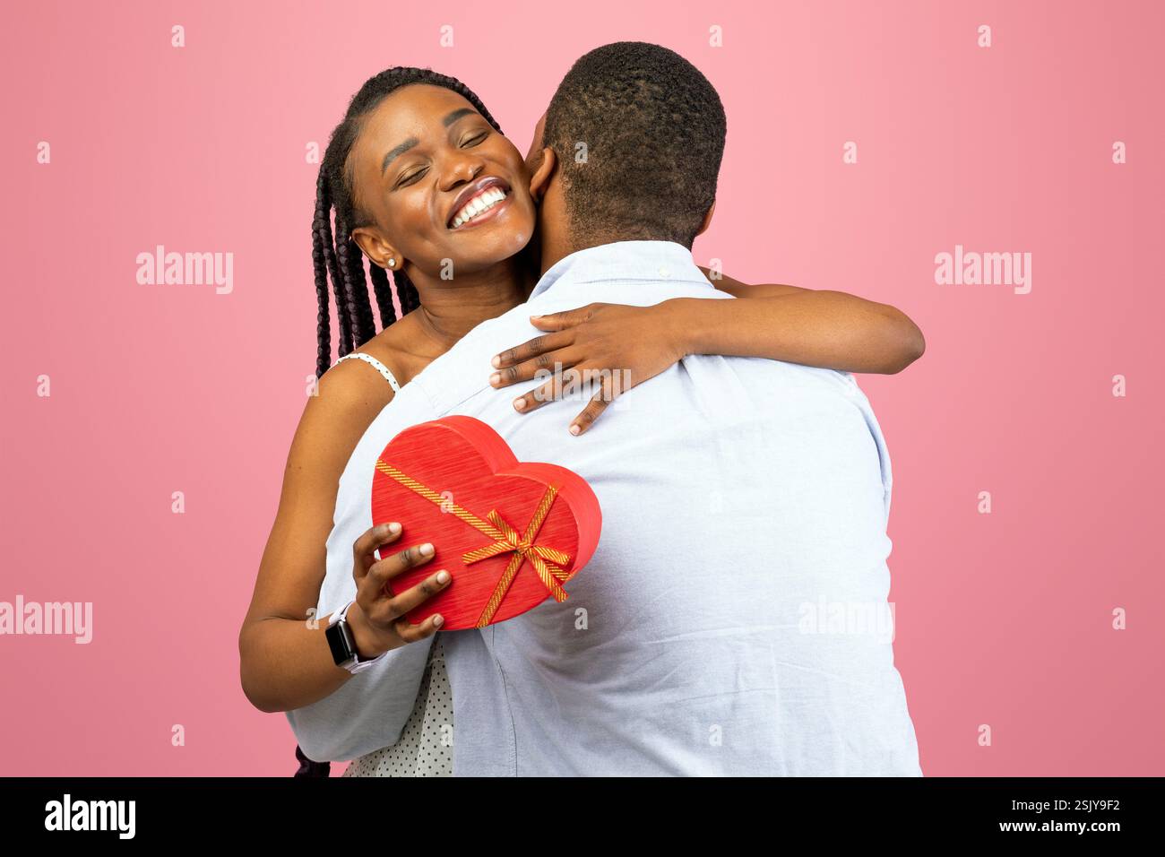 Happy black man making surprise for woman giving box Stock Photo - Alamy