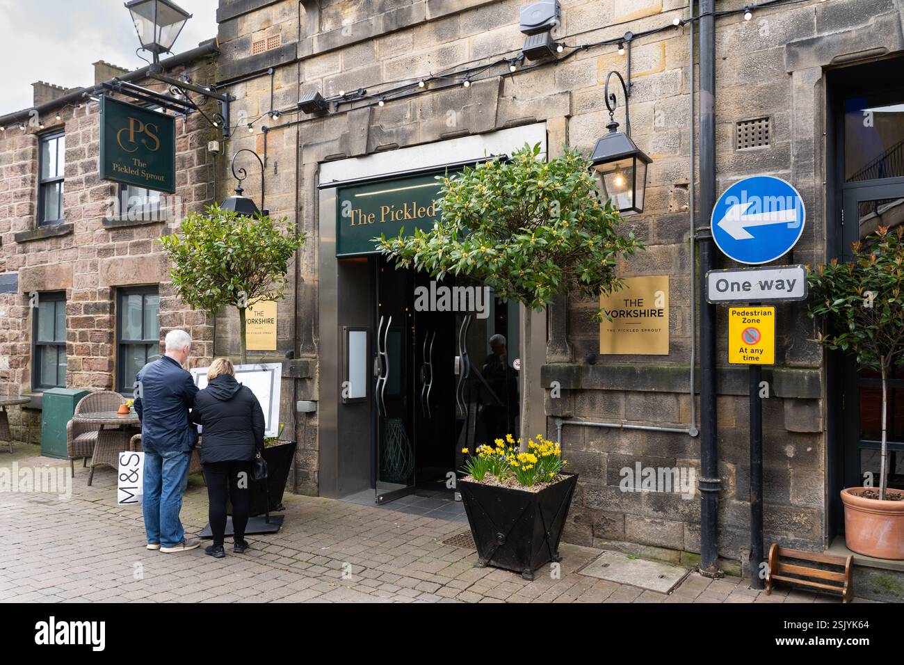 Couple looking at a menu outside The Pickled Sprout, a botanical ...