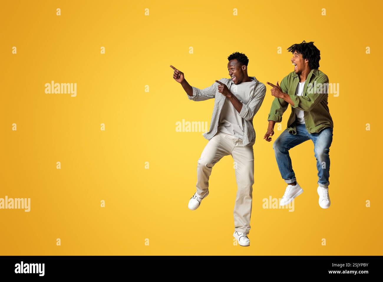 Look At This. Joyful Black Guys Pointing Aside While Jumping In Air ...