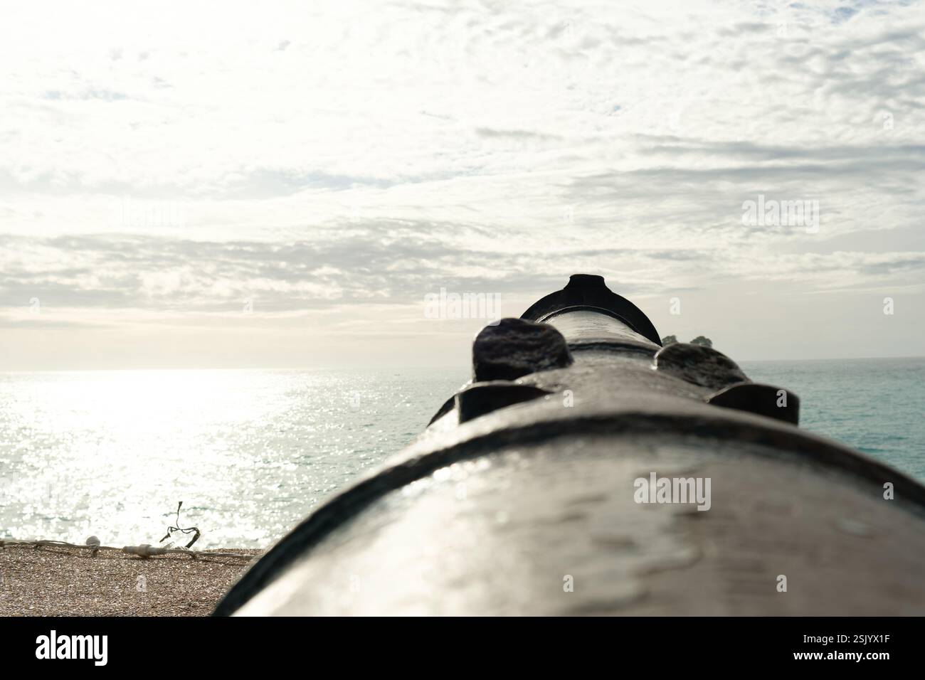 Historic muzzle-loading cannon facing the Mediterranean Sea at sunset ...