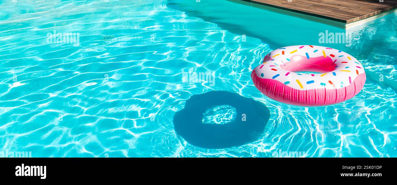 Pink donut inflatable float in turquoise swimming pool with shadow and ...