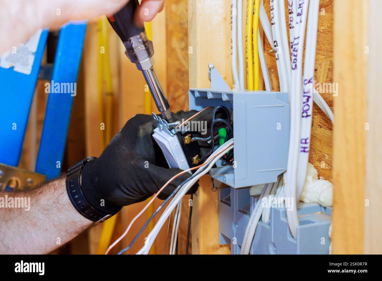 Electrician worker is attaching wires to new electrical outlet ...