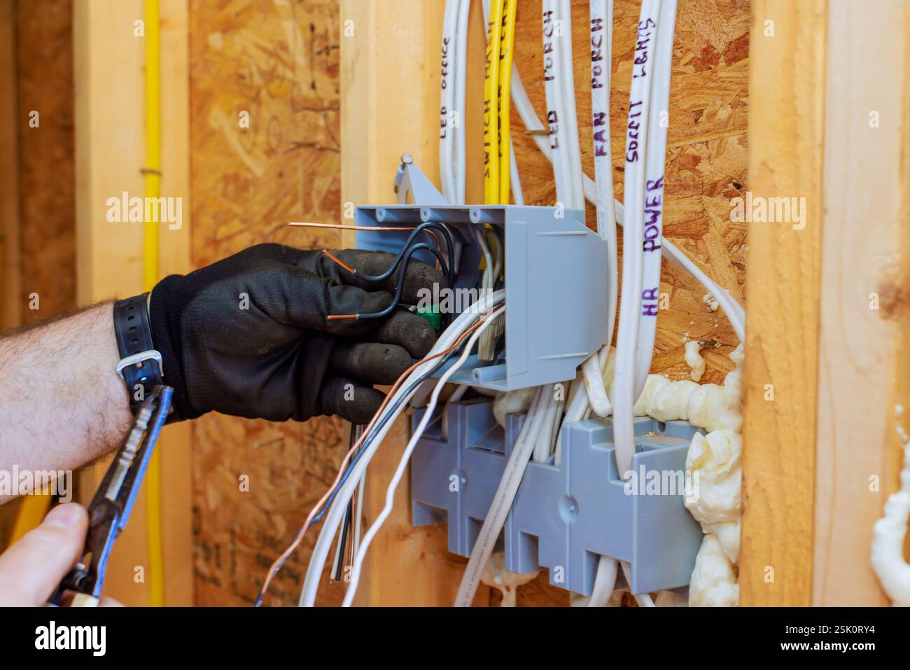 Electrician connects wires inside circuit box while renovating home ...