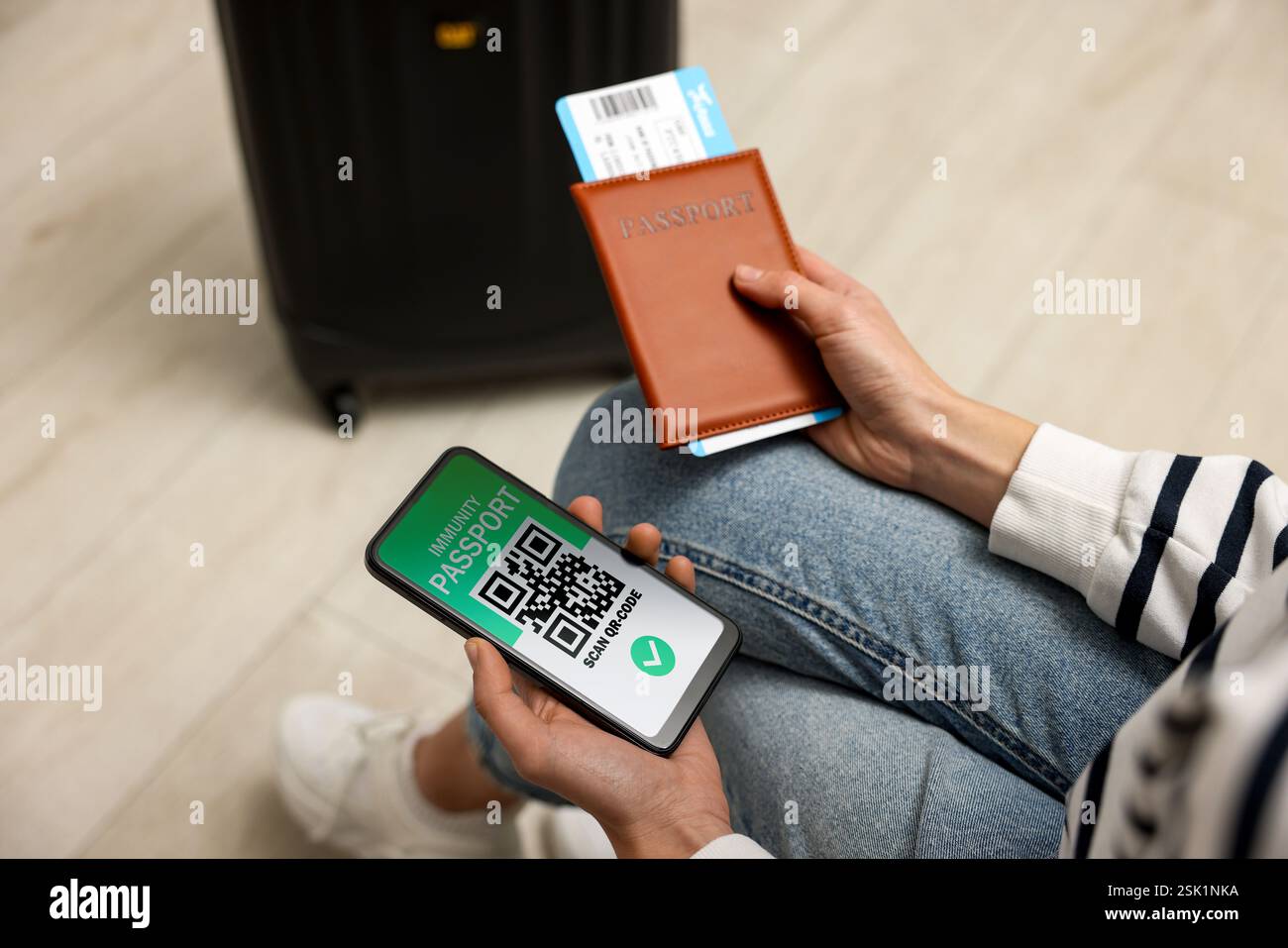 Tourist with passport, flight ticket and mobile phone indoors, above ...