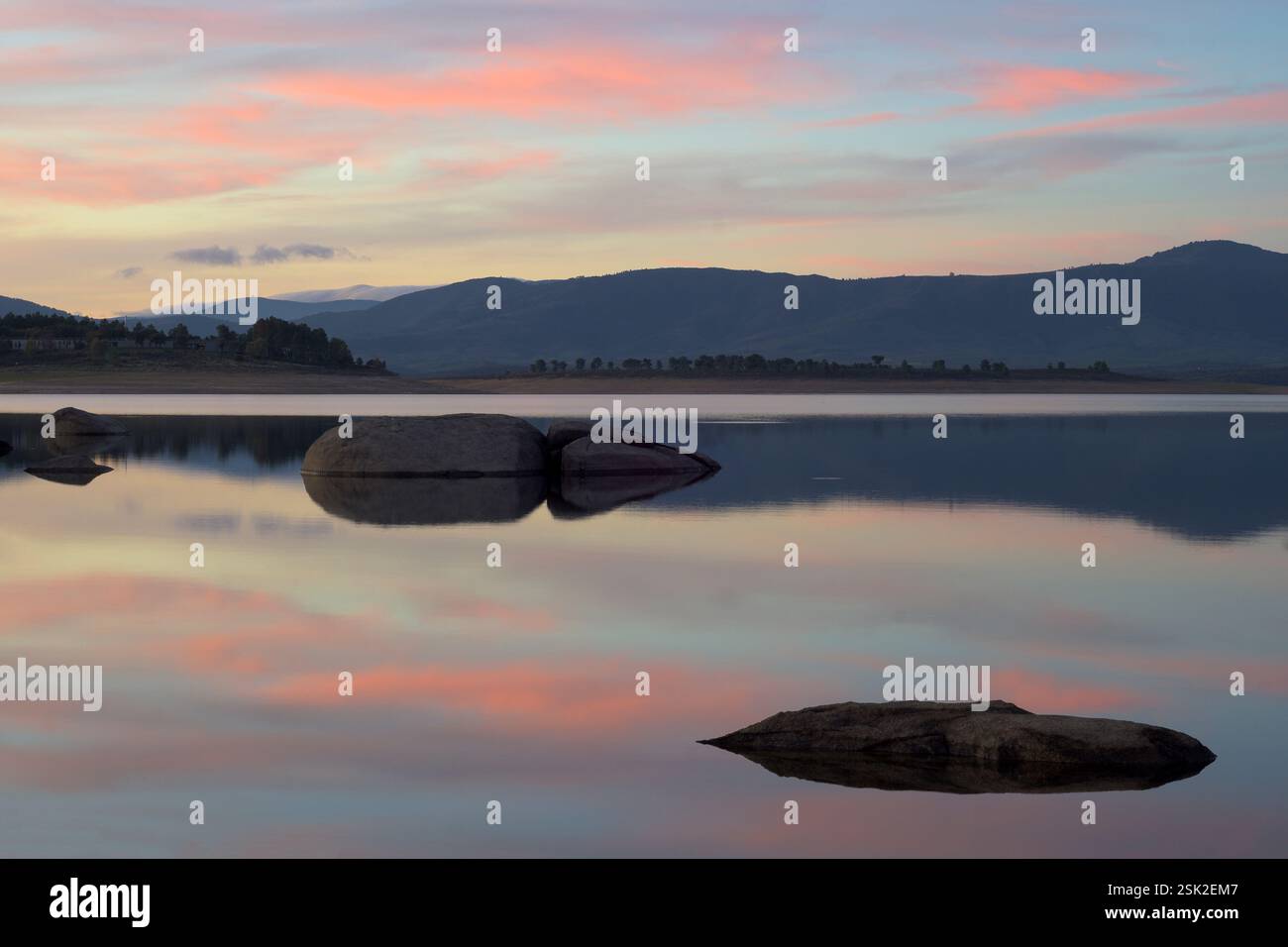 Calm swamp at sunset with rocks and soft colors in the sky in ...