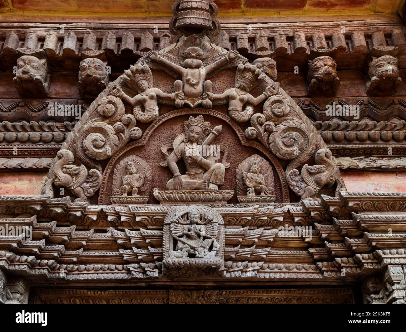 A intricatly carved wooden lintel over a Newari Buddhist temple door in ...