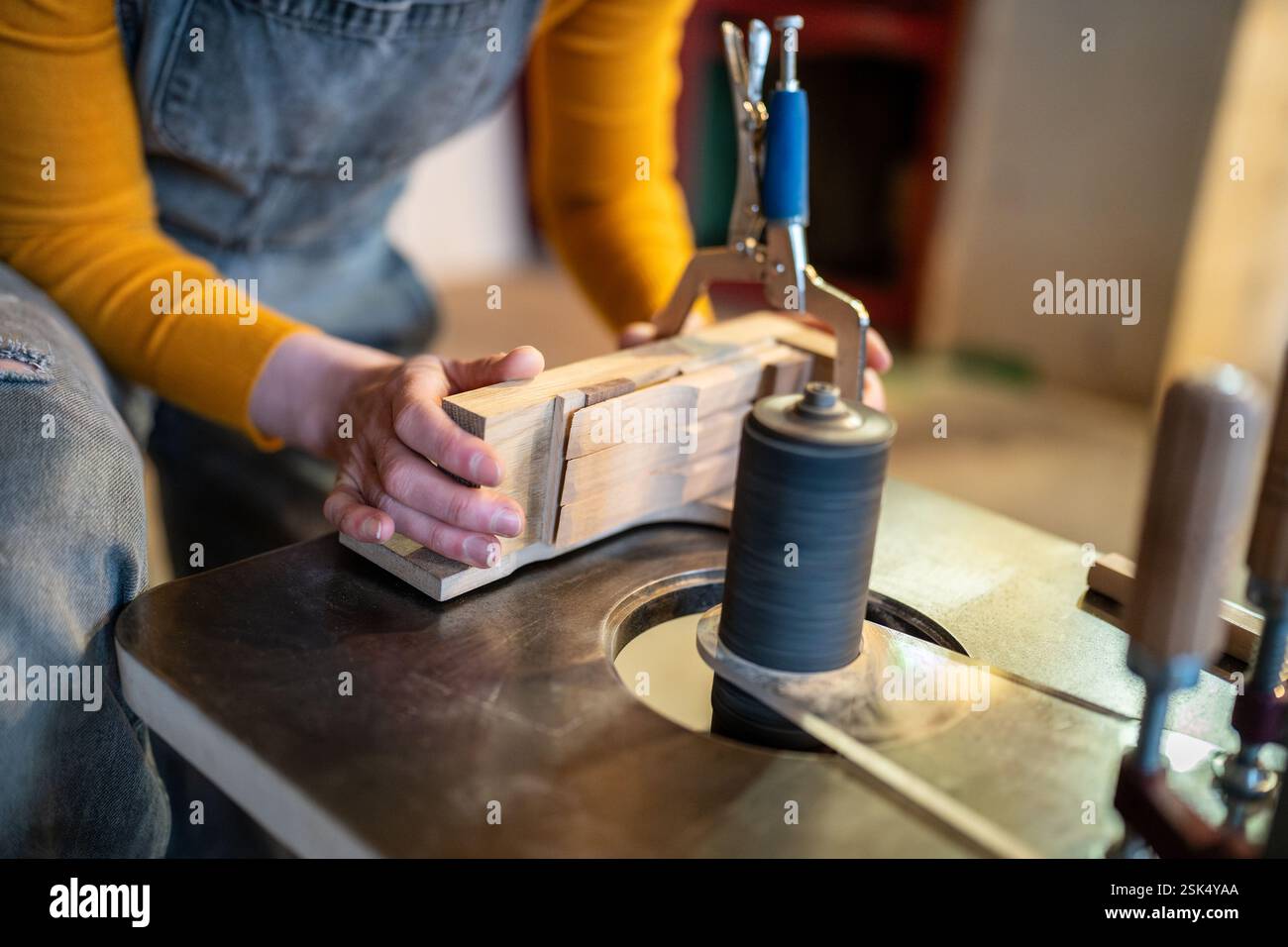 Carpenter hands shape and refine wooden knife blanks on lathe, sand and ...