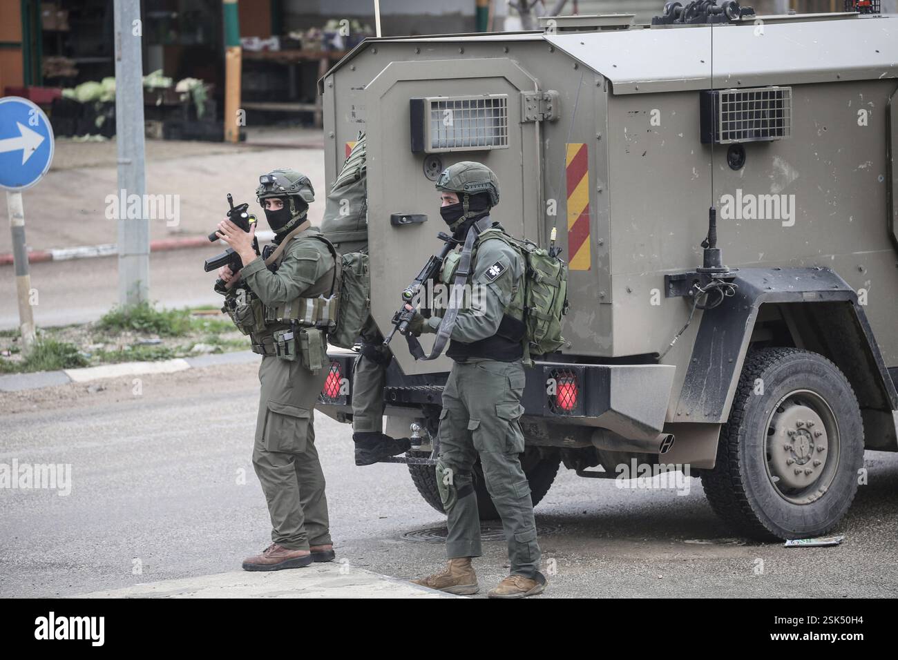 An Israeli commando soldier points his weapon in the middle of a market ...