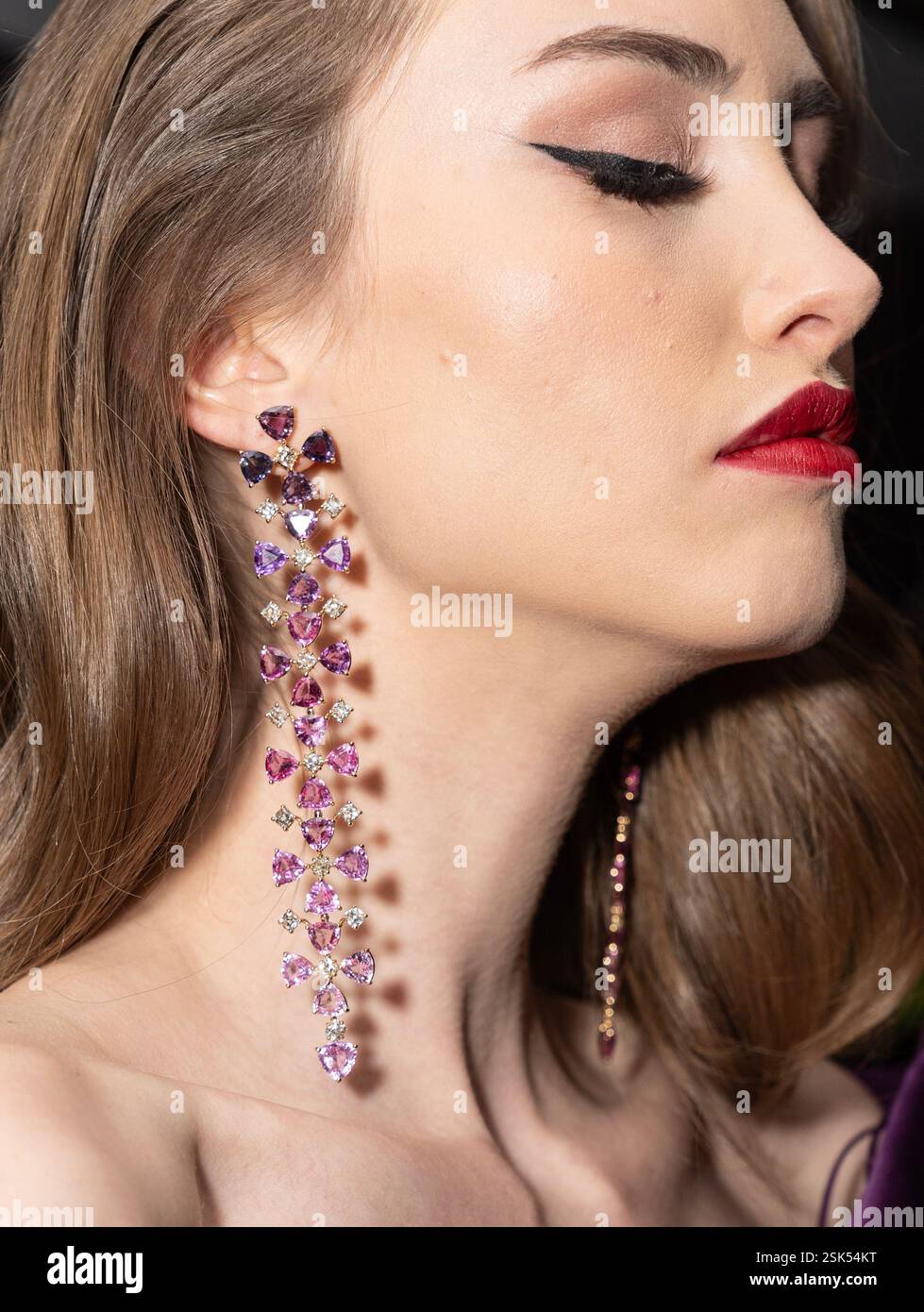 A model wearing jewelry by Chopard prepares backstage for runway for Pamella Roland runway show ...