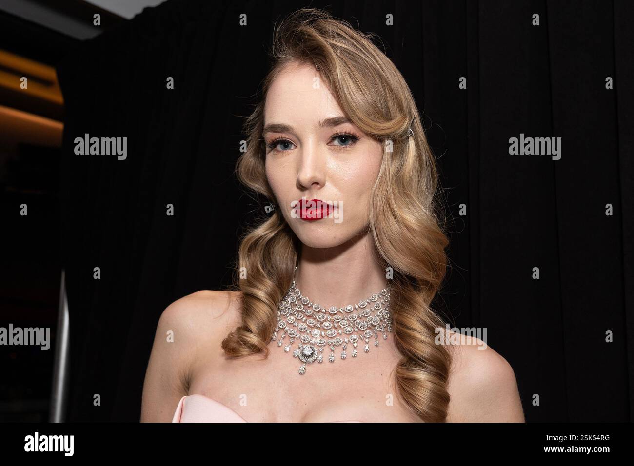 A model wearing jewelry by Chopard prepares backstage for runway for Pamella Roland runway show ...
