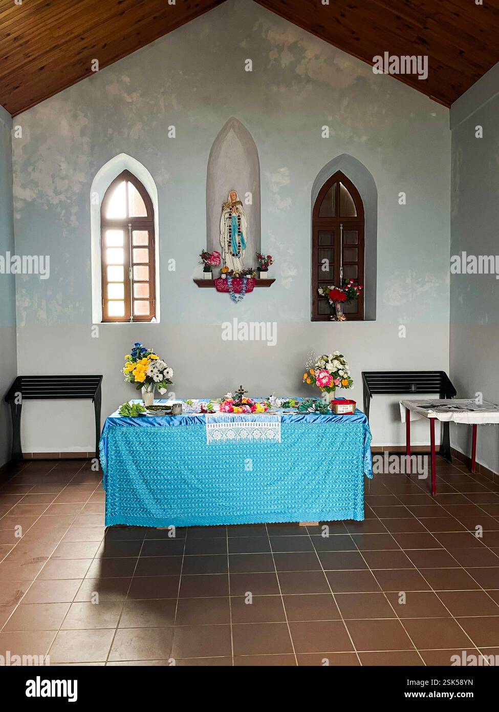 Very modest interior of the Church of our Lady of Lourdes with a simple ...