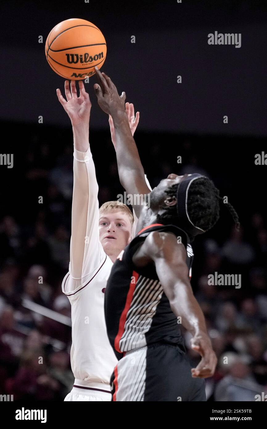 Georgia forward Dylan James, right, gets a finger to disrupt a shot by ...