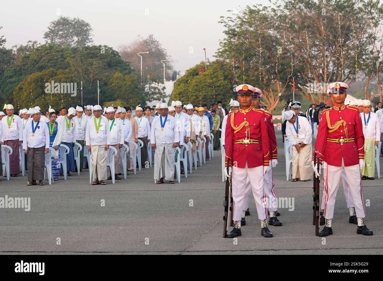 Myanmar government officials and members of the honor guard stand at ...