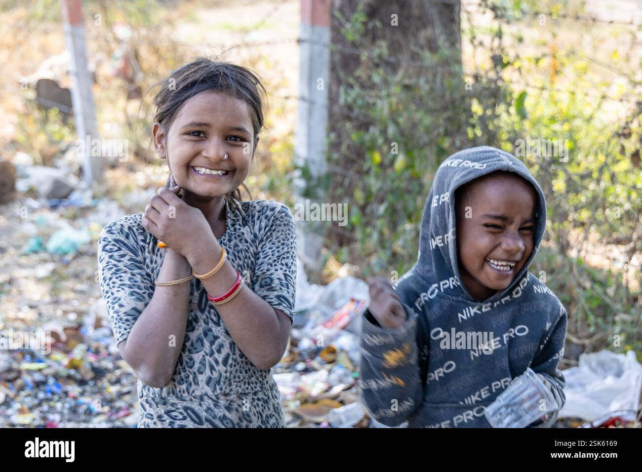 young poor garbage collecting kids with cute smiling facial expression ...
