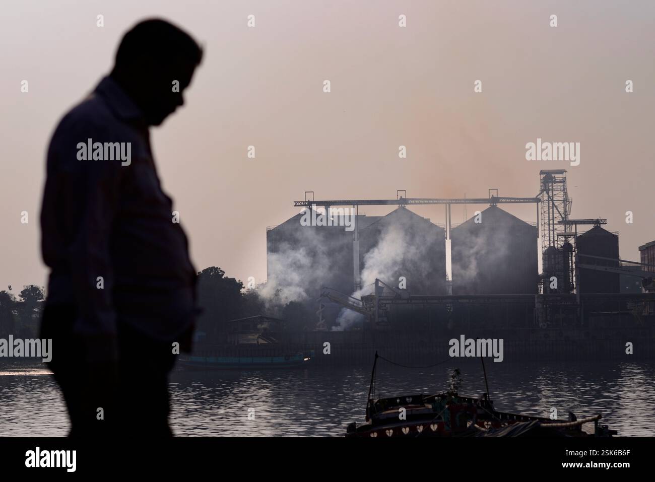 A man walks past an industrial plant in Dhaka, Bangladesh, on Feb. 9 ...