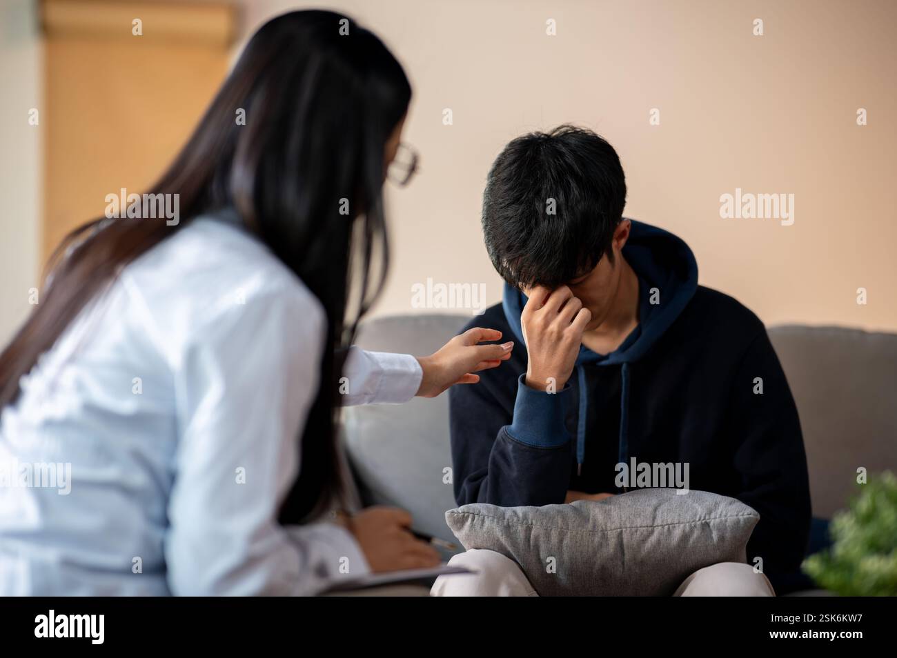 A sad, depressed young Asian man receives mental health advice from a ...