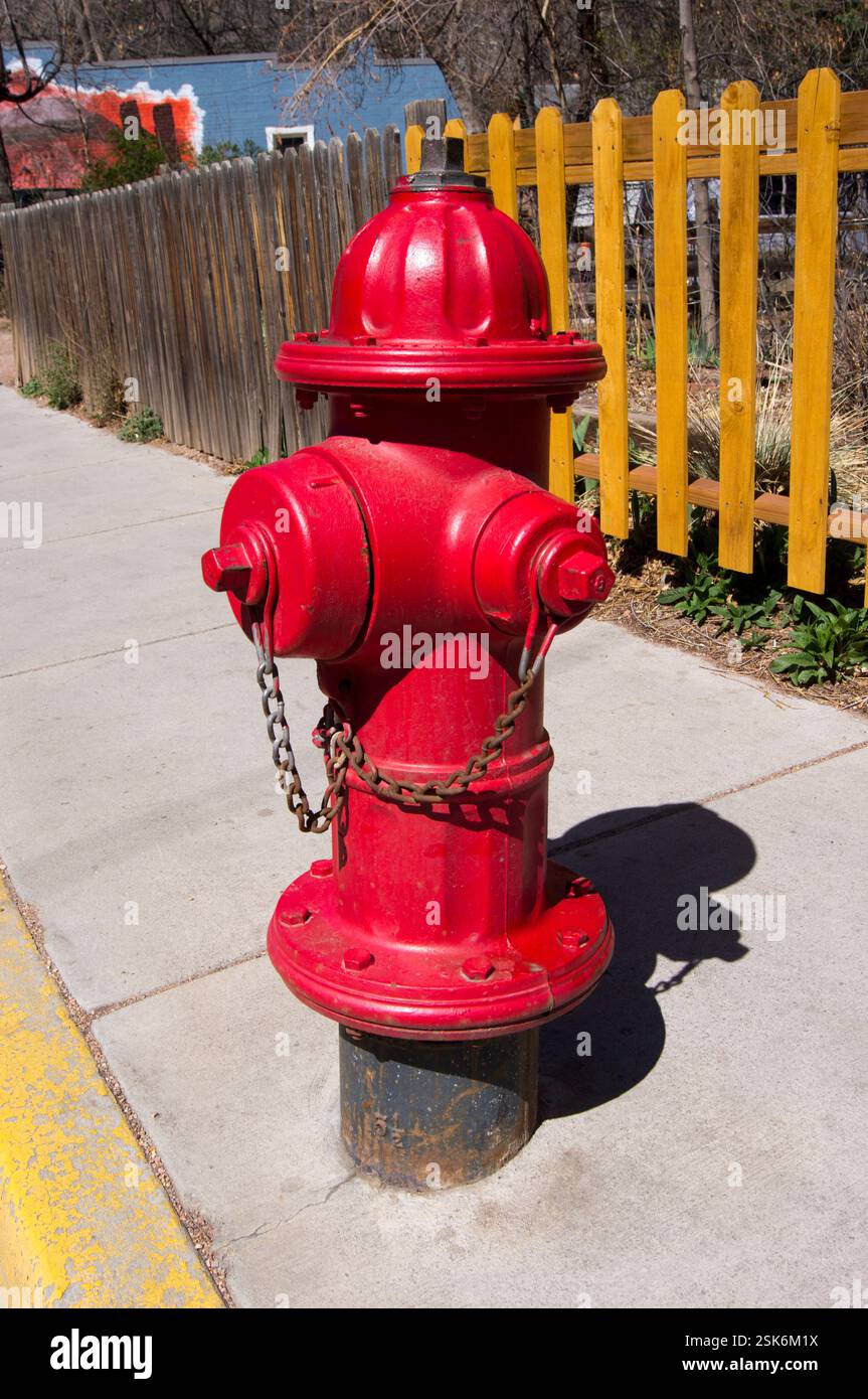 A bright red-painted fire hydrant in a side street in Manitou Springs ...