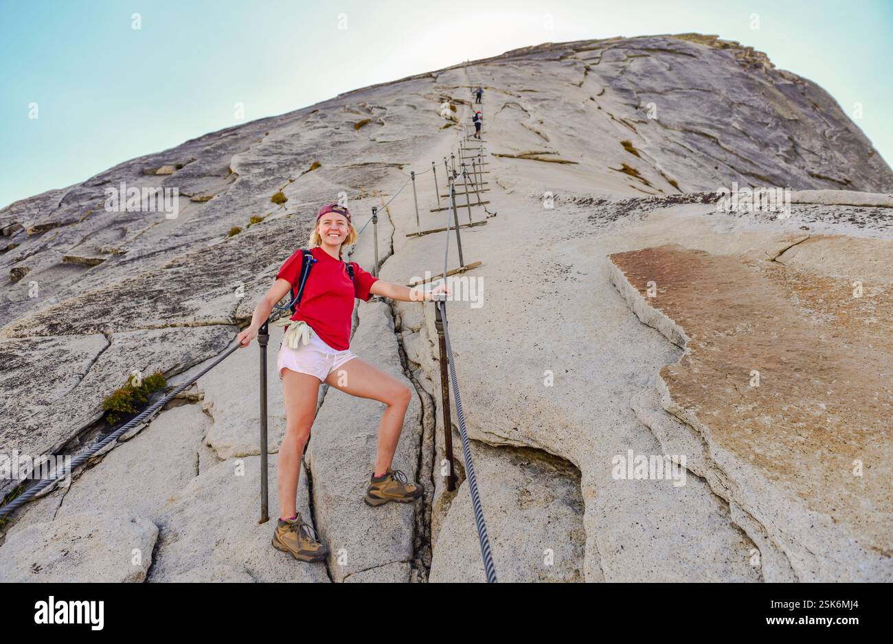 Girl looking out from dangerous Half Dome Cable Hike in Yosemite ...
