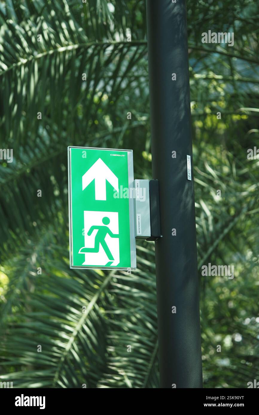 Emergency exit sign guiding people in a lush outdoor setting Stock ...