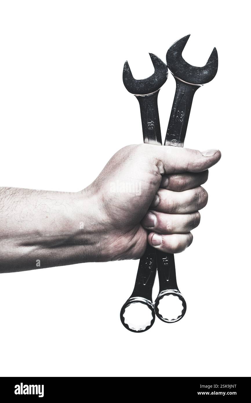 Holding two wrenches tightly in a fist showcases strength and ...