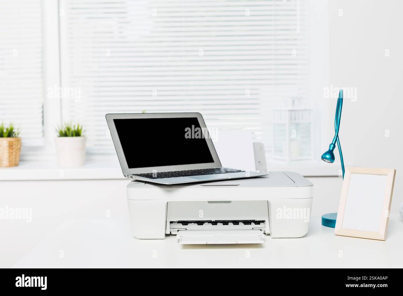 Modern workspace setup with laptop, printer, and desk accessories in a ...