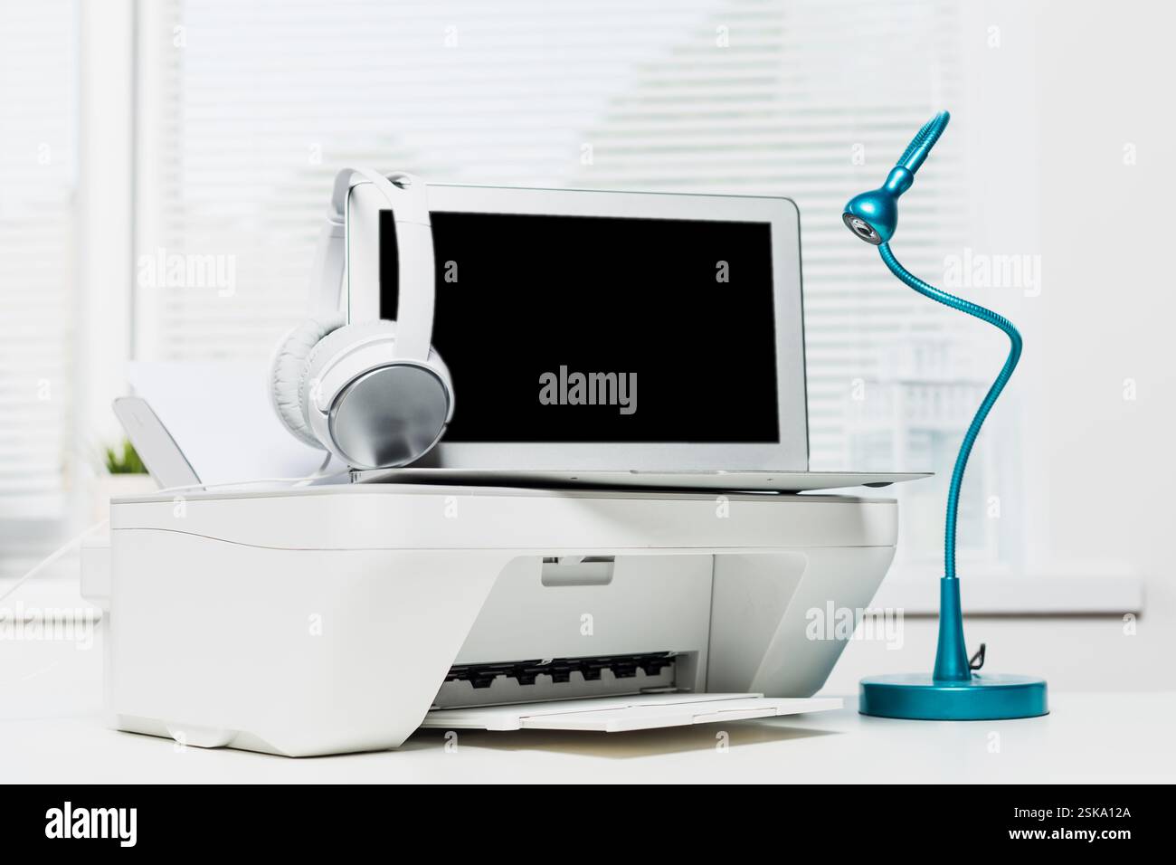 Modern workspace featuring a computer, printer, and stylish desk lamp ...