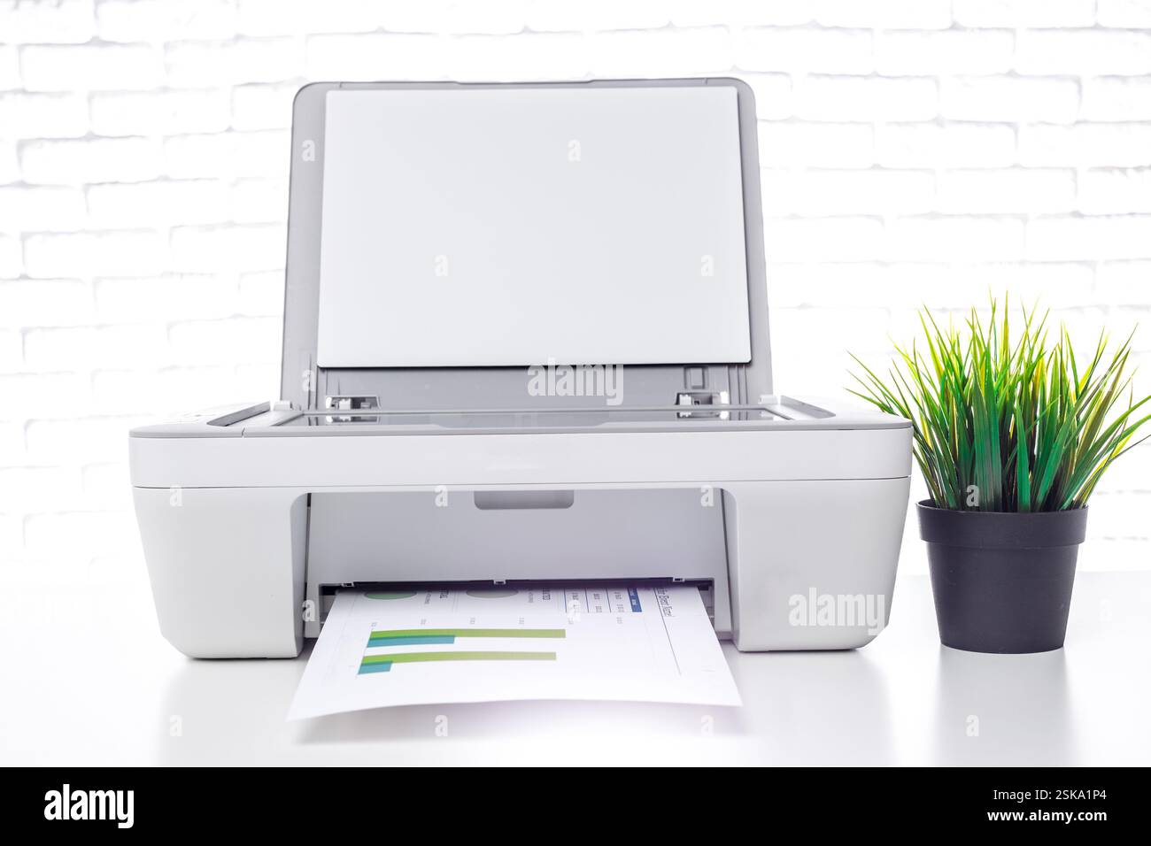Modern printer with documents being printed on clean white desk ...