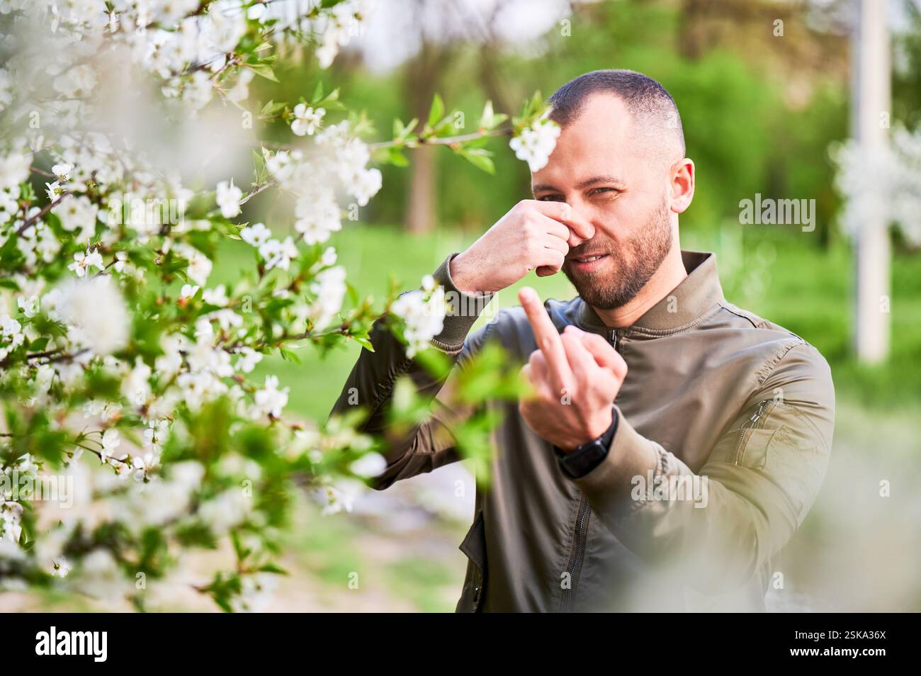 Man allergic suffering from seasonal allergy at spring in blossoming ...