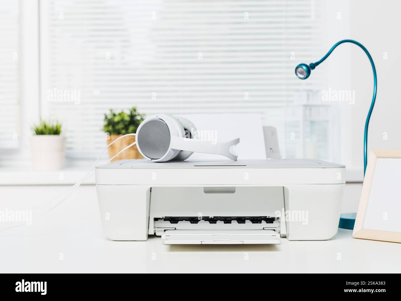 Modern workspace with printer and headphones in bright, organized ...