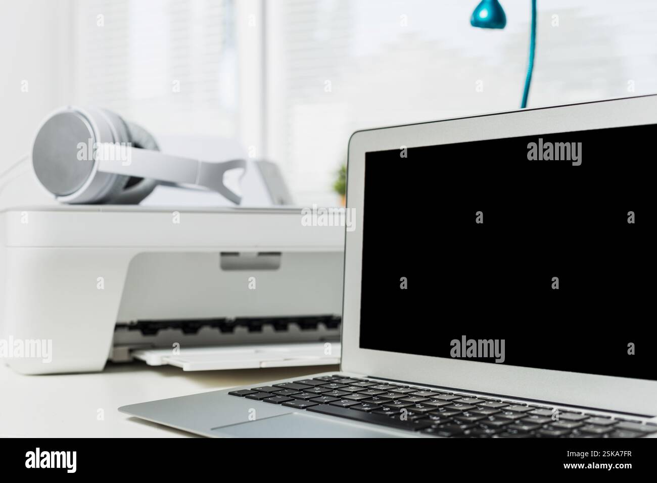 Workspace setup featuring a modern laptop and printer in a bright ...