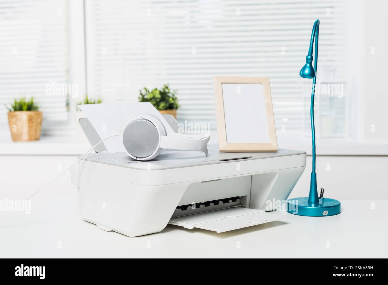 Modern workspace with printer, lamp, and decorative frame in a well-lit ...