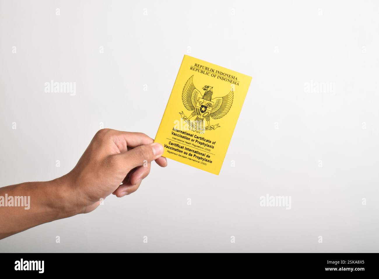 Hands holding Indonesian Vaccination Certificate or International ...